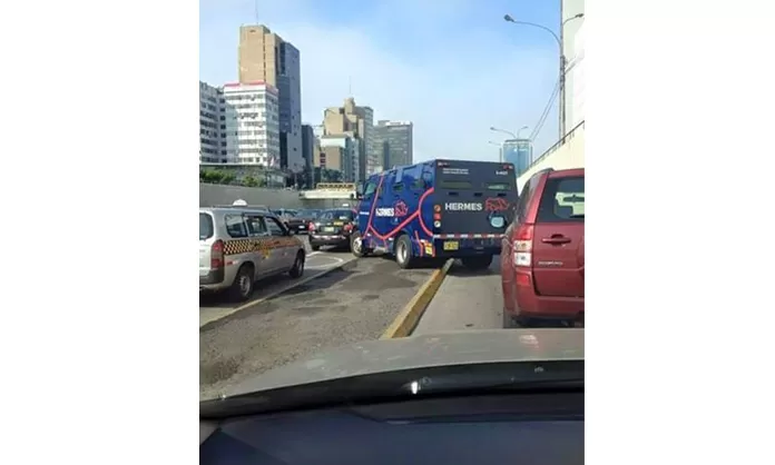 Camión de caudales evita el tráfico por encima de una berma en la Vía ...